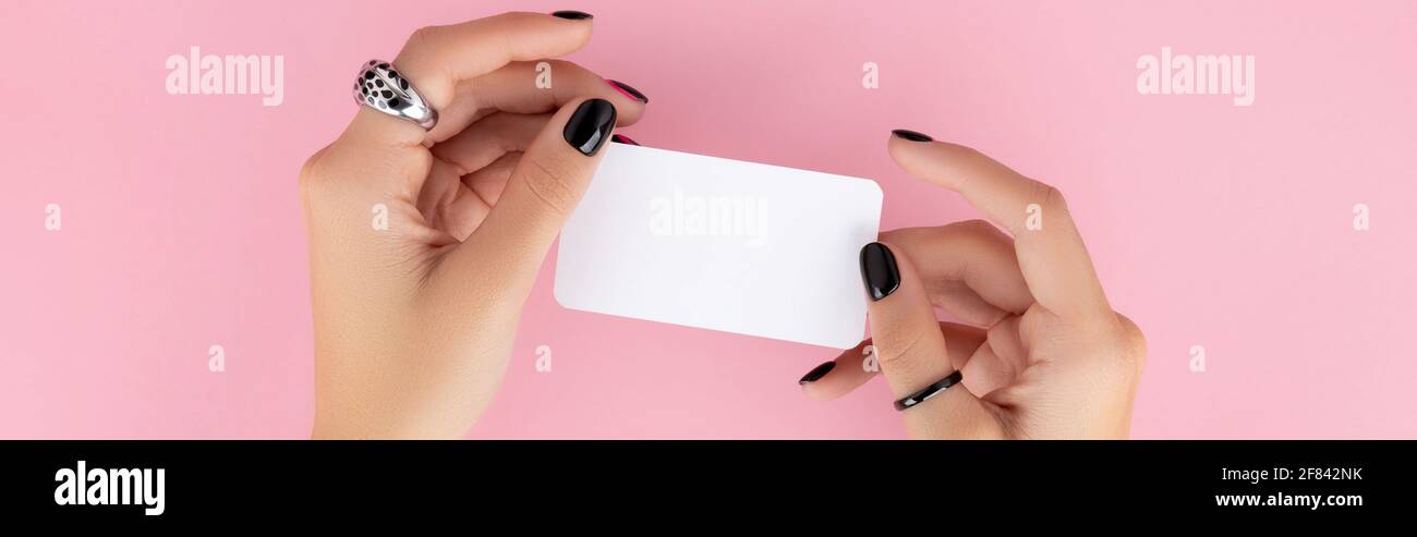 Manicured womans hand holding postcard on pinkbackground Stock Photo ...