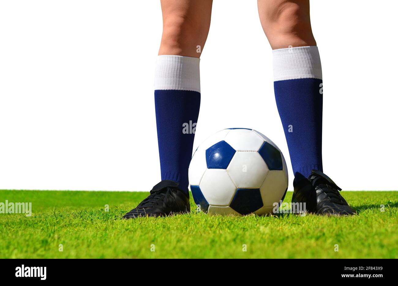 Feet of soccer player with ball on football field on white background ...