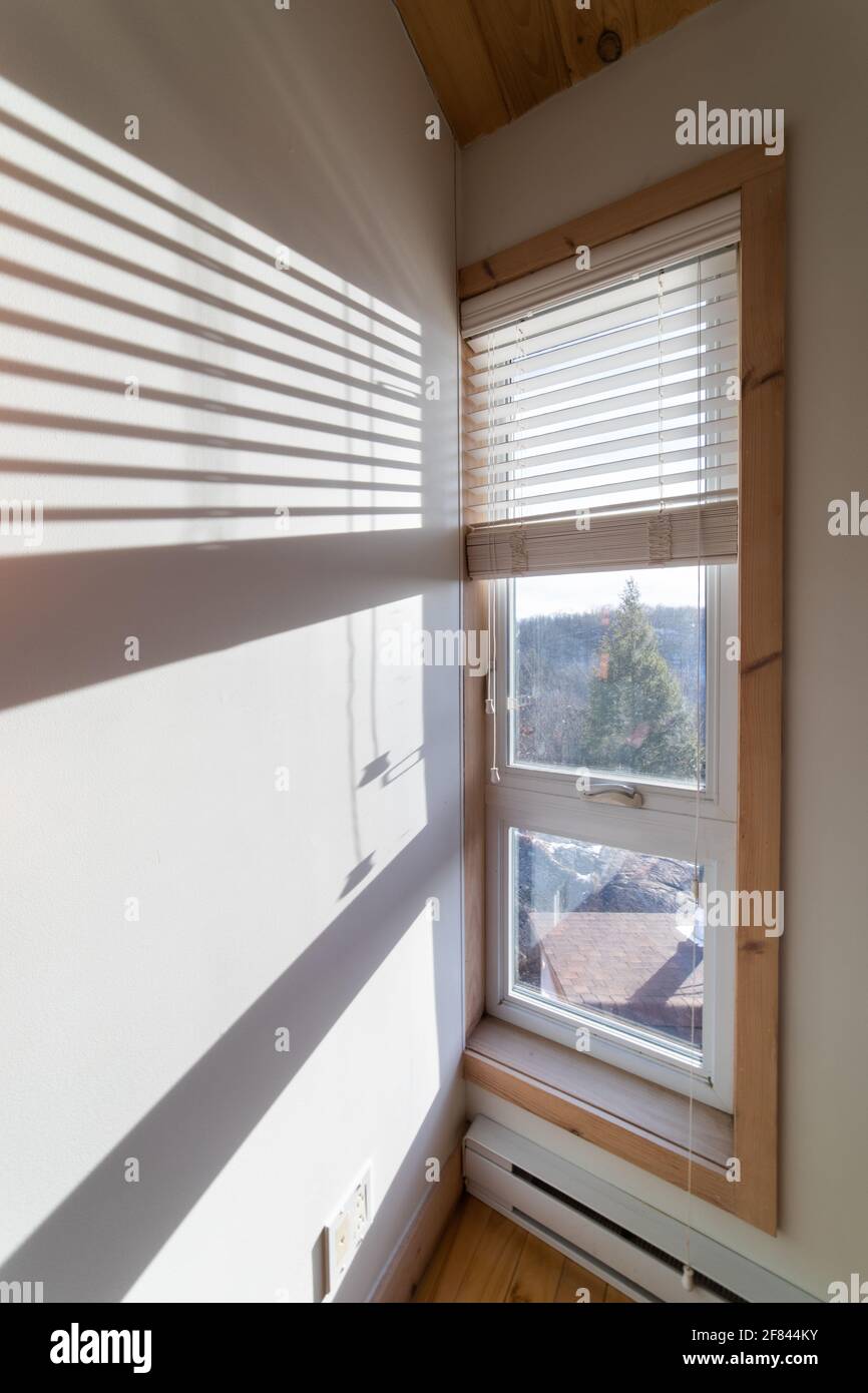 view of a window with shadows on the wall created by the blinds and ...