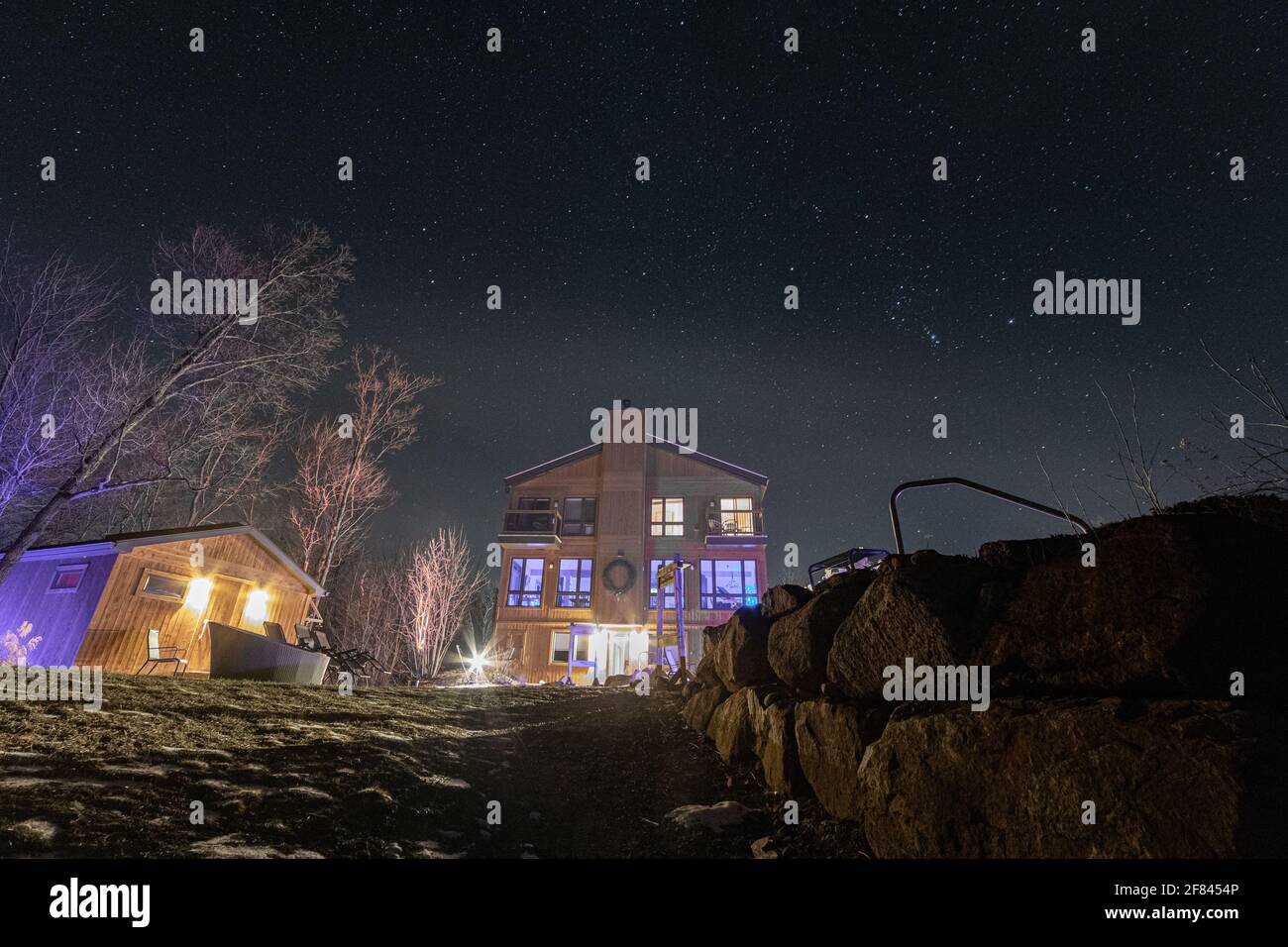 view of a cottage at night with light coming from the windows Stock ...