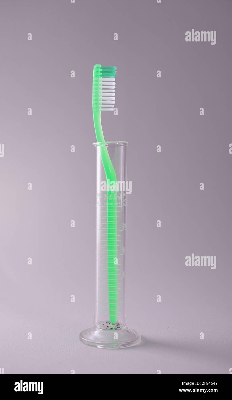 A vertical shot of a green toothbrush isolated on white background ...