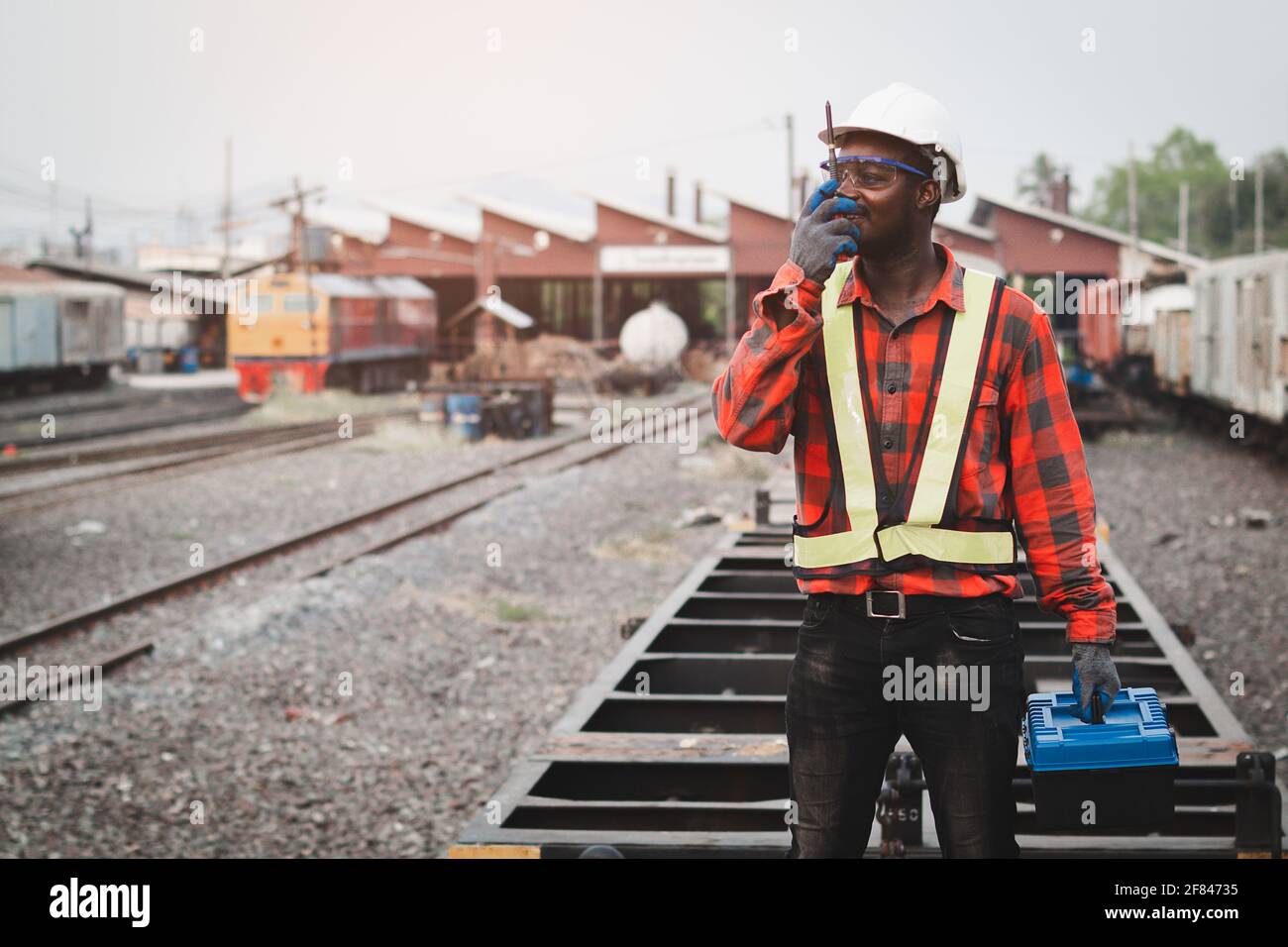 African American male contractor using tablet PC with stacked wooden ...
