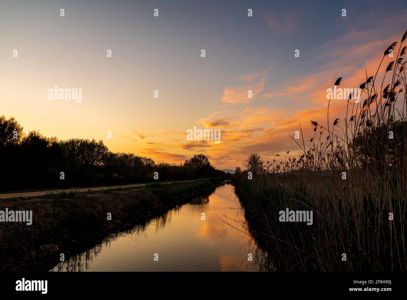 River reflecting red clouds during sunset. Silhouette of typical ...