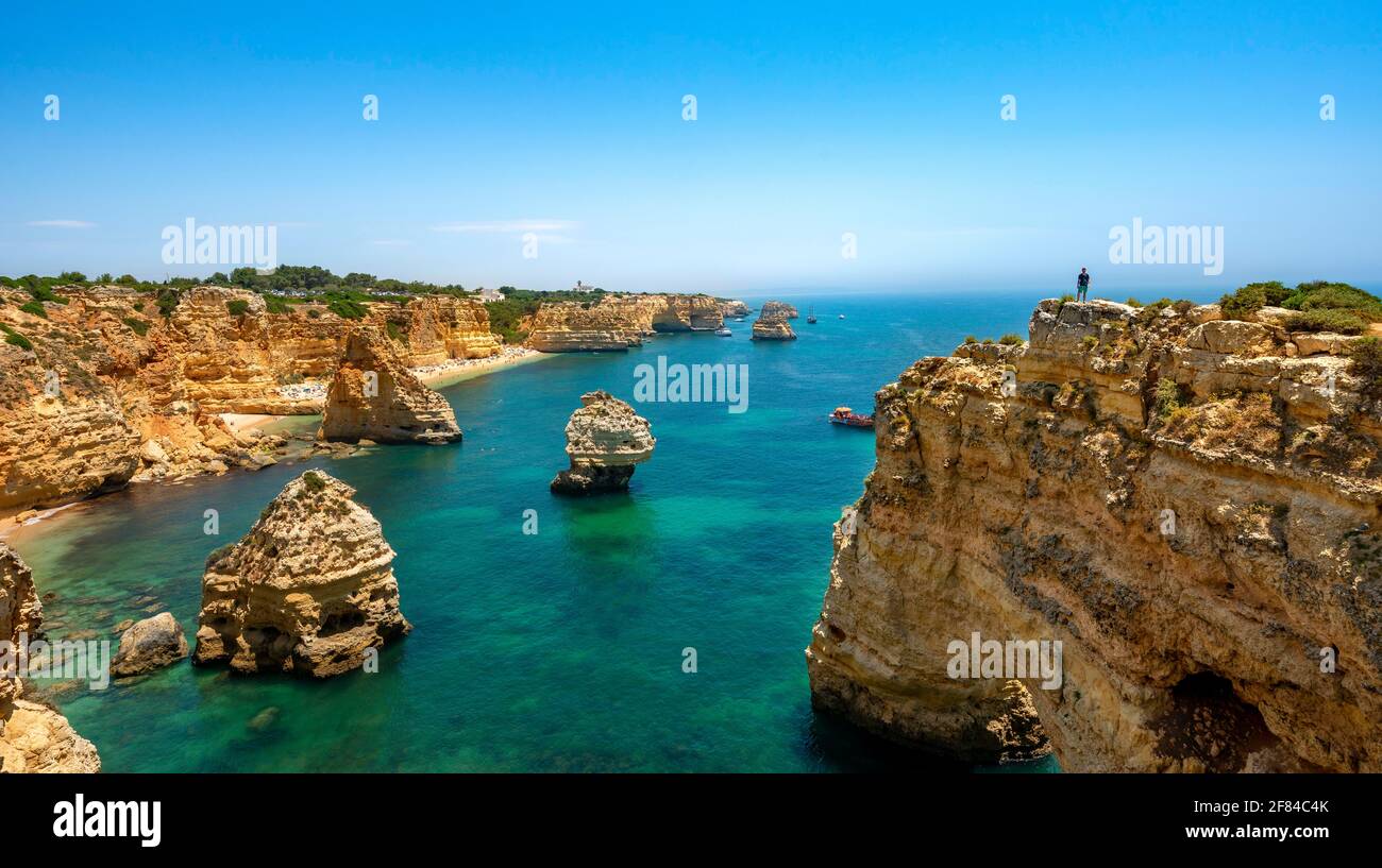 Young man standing on a rock on the cliff, view of cliff of craggy ...