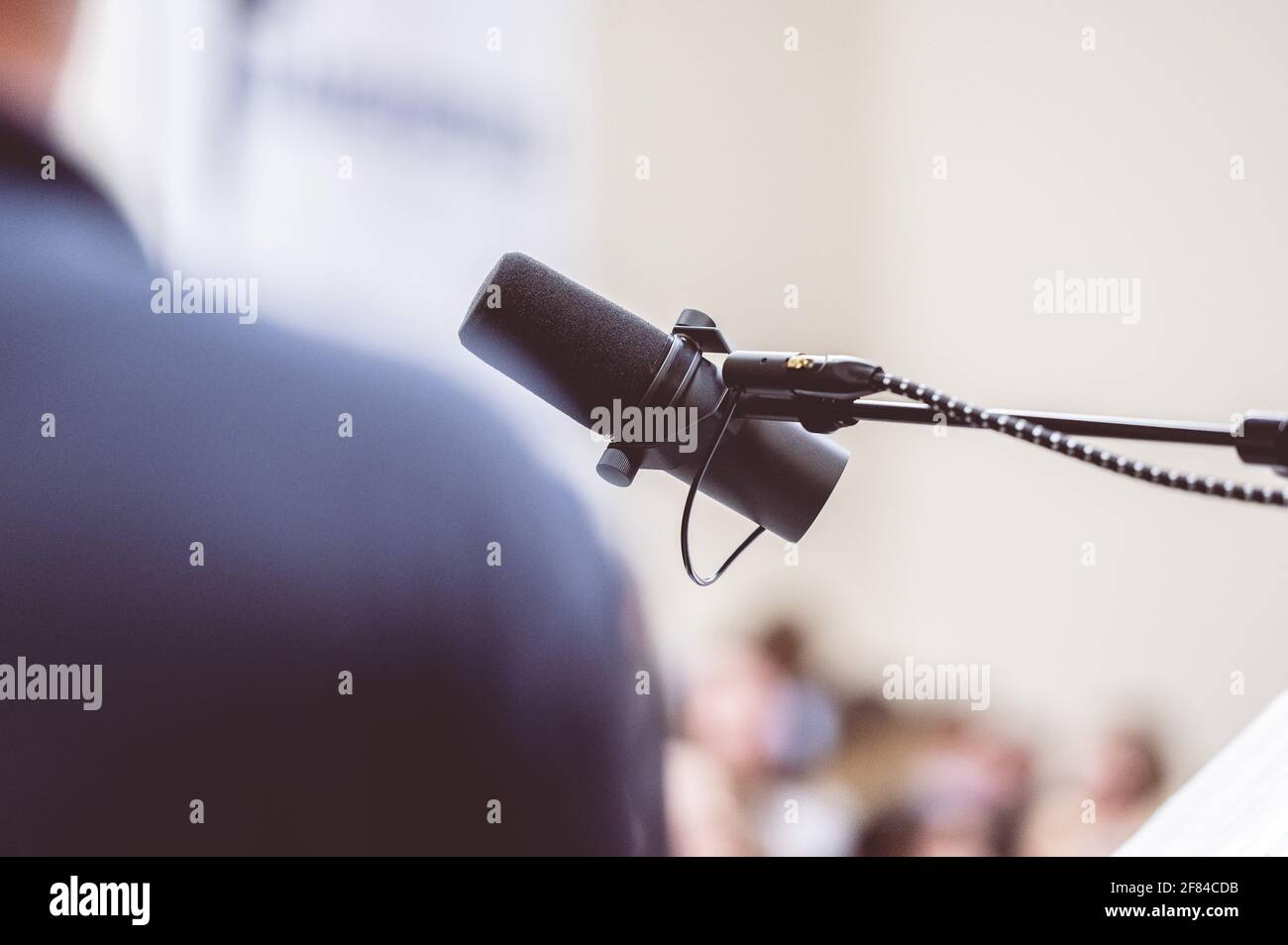 A man talking on the microphone on stage - public speech Stock Photo ...