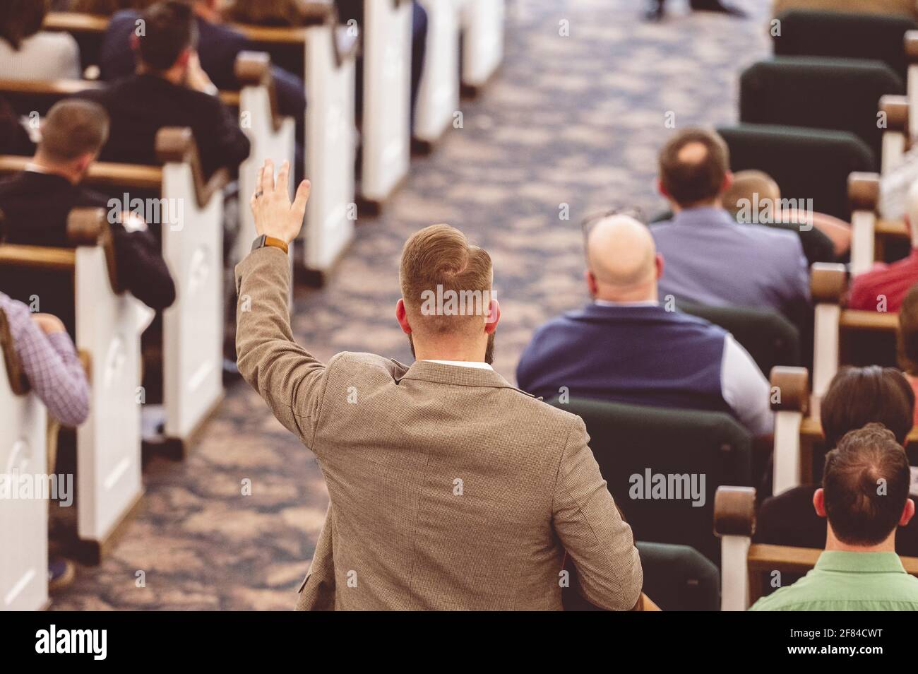 A man raising hand during a congregation in a church Stock Photo - Alamy