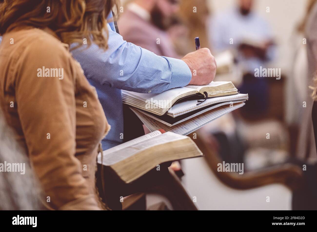 The church choir members holding sheet music and singing during a ...