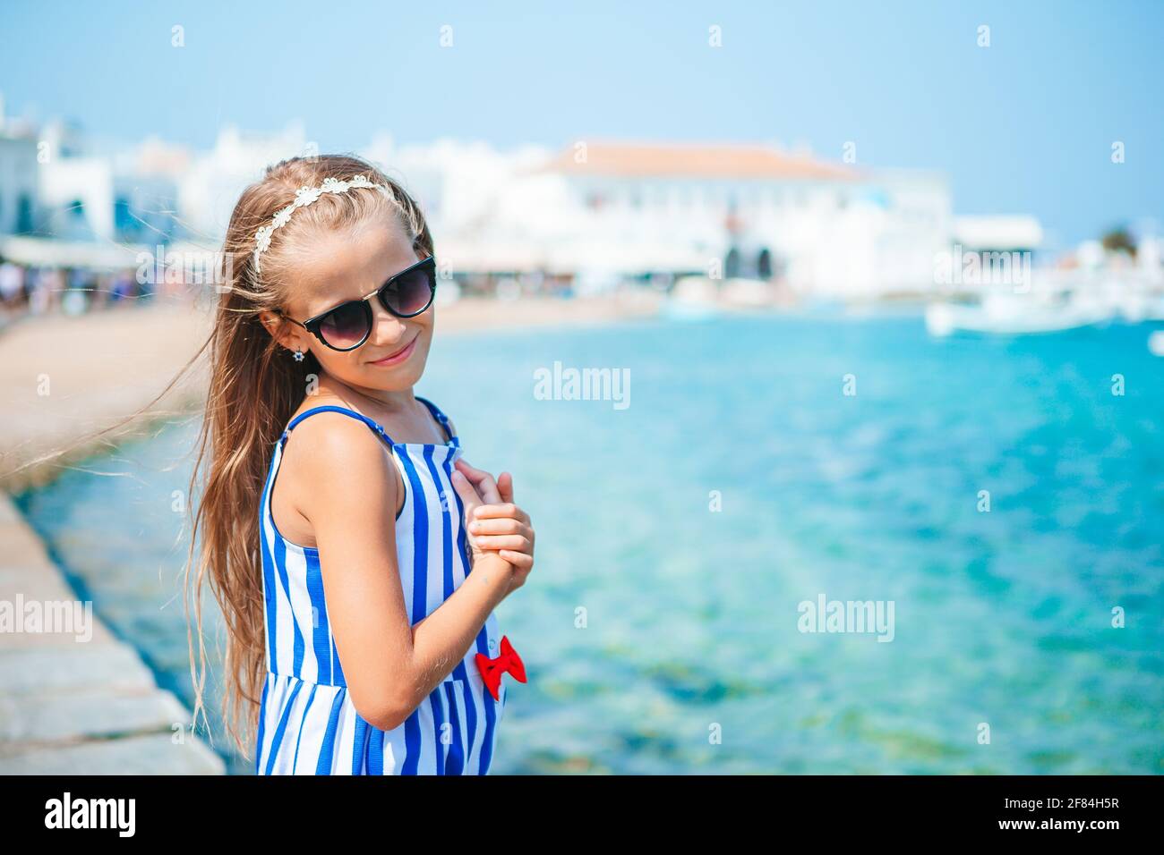 Adorable little girl at old street of typical greek traditional village ...