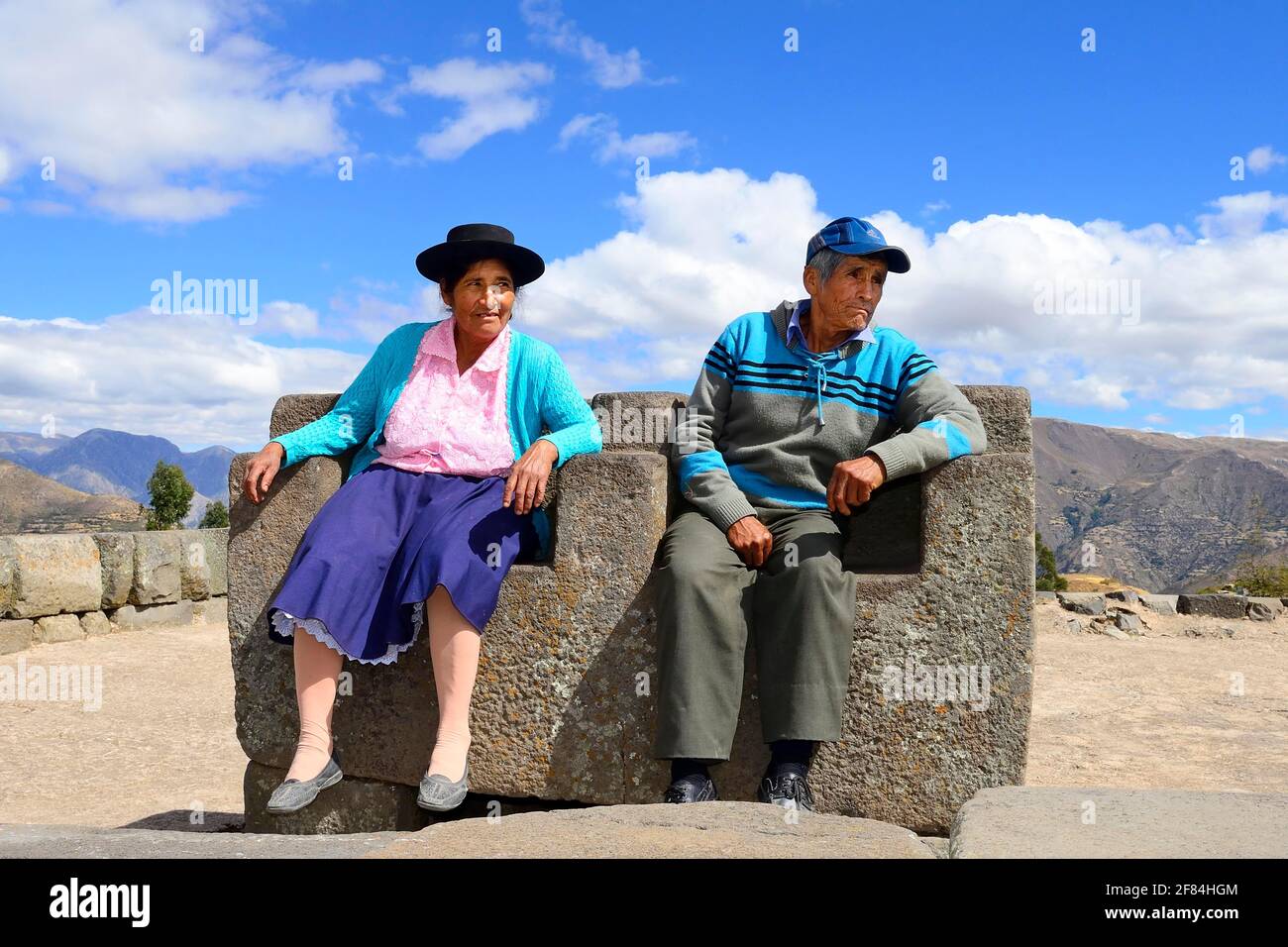 Old indigenous couple sitting on the throne of the Inca on the pyramid ...