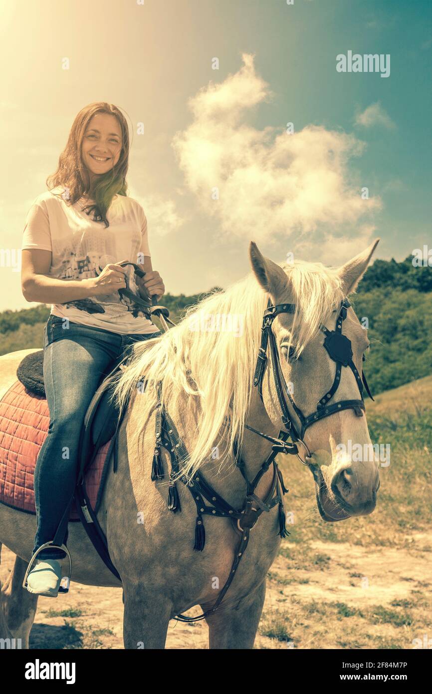 the rider on the white horse. Young horsewoman riding on white horse ...