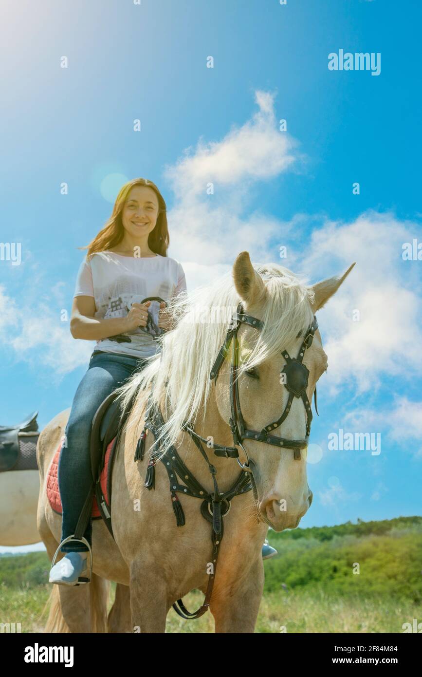 the rider on the white horse. Young horsewoman riding on white horse ...