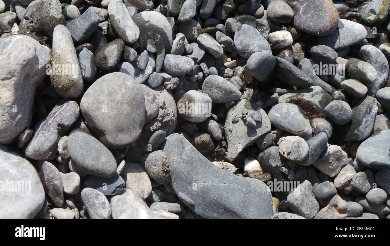a top view of wet and dry gray pebbles and rocks - for background or ...