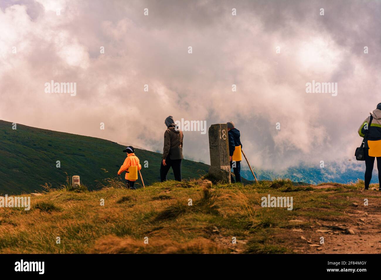 Tourists follow a mountain trail on a tourist sign to the next ...