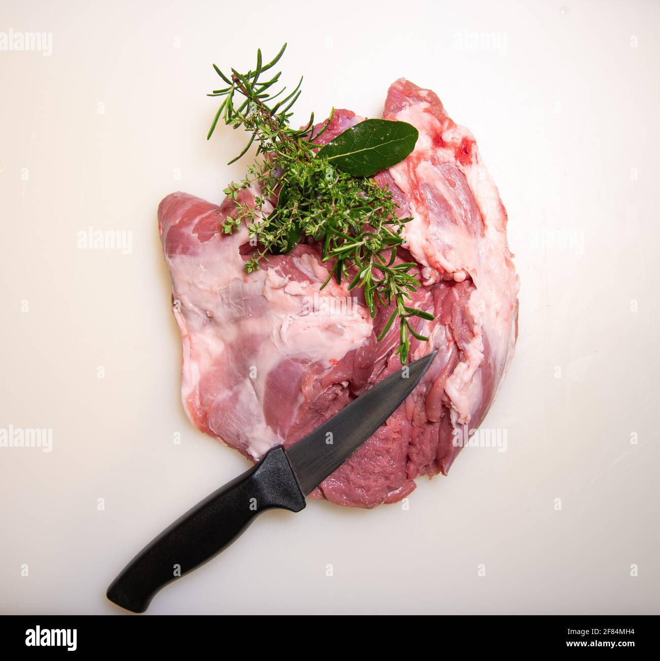 Boning a shoulder of lamb leg meat on a wooden tray, white background ...