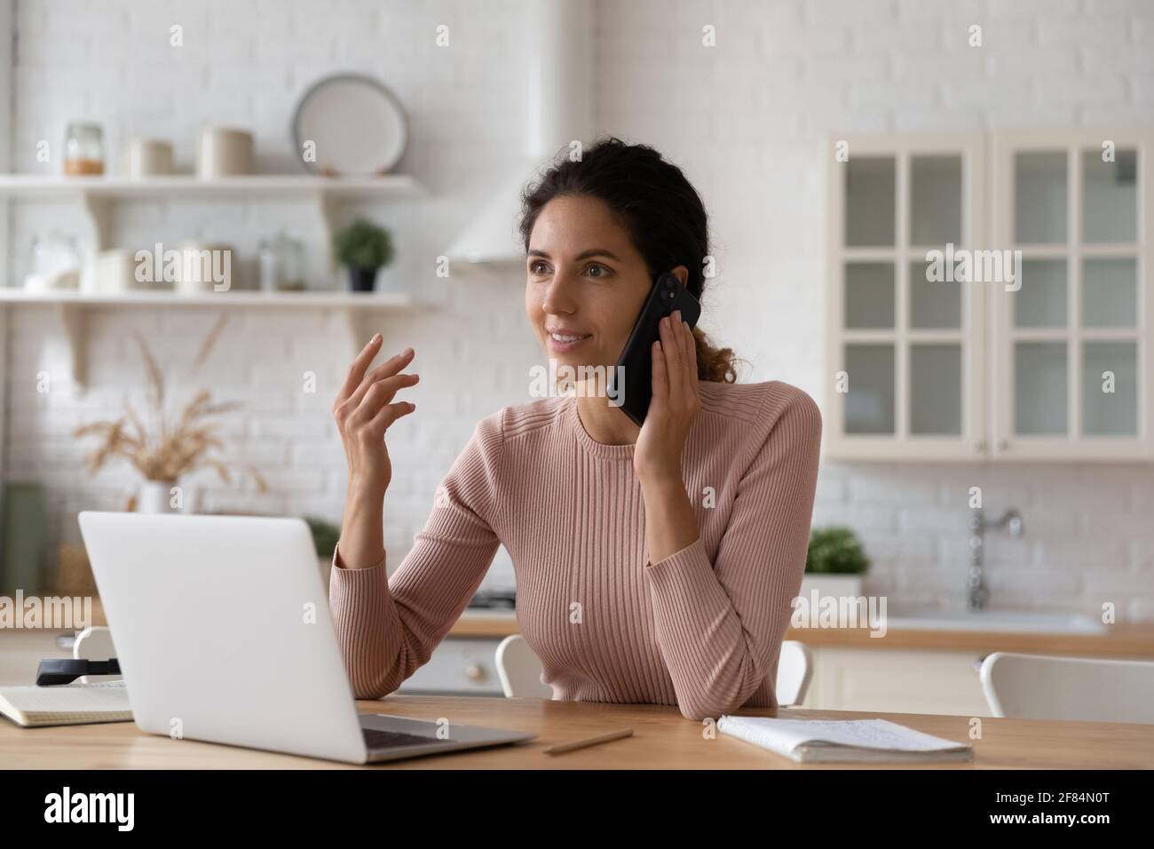 Inspired hispanic woman remote worker sitting by laptop making call ...