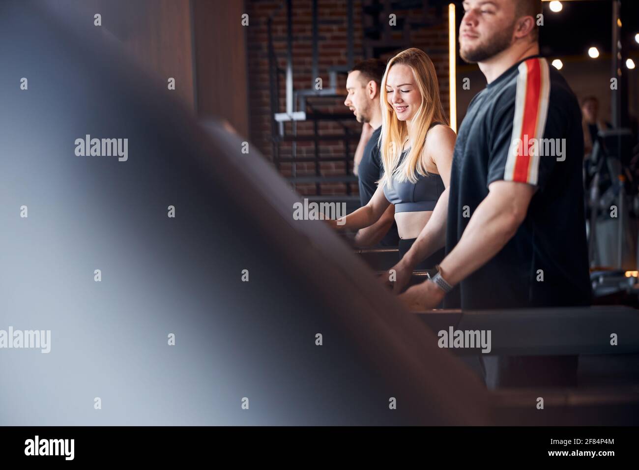 Smiley blonde lady exercising on a treadmill Stock Photo - Alamy