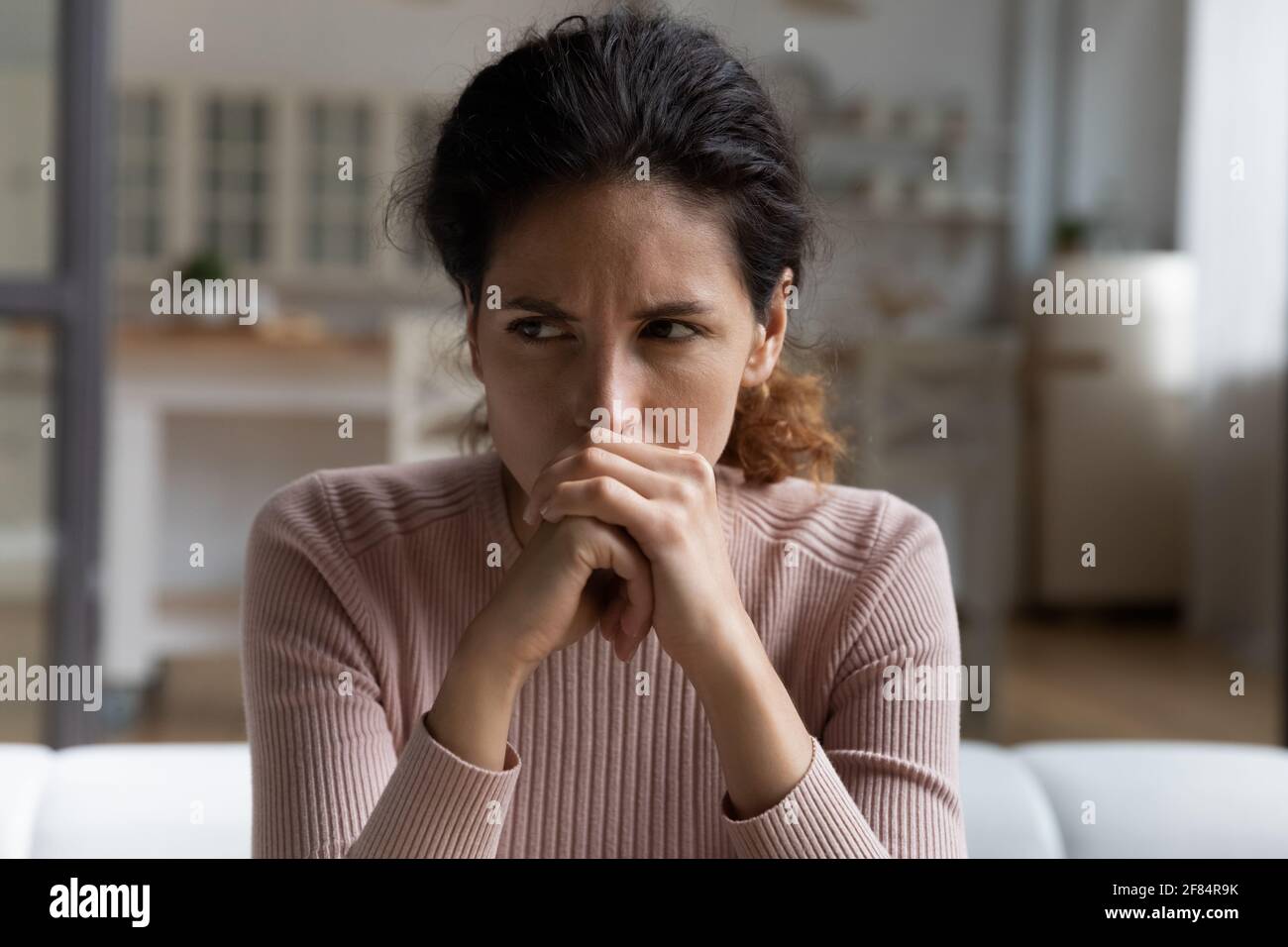 Thoughtful unhappy latin female sit on couch with sad look Stock Photo ...