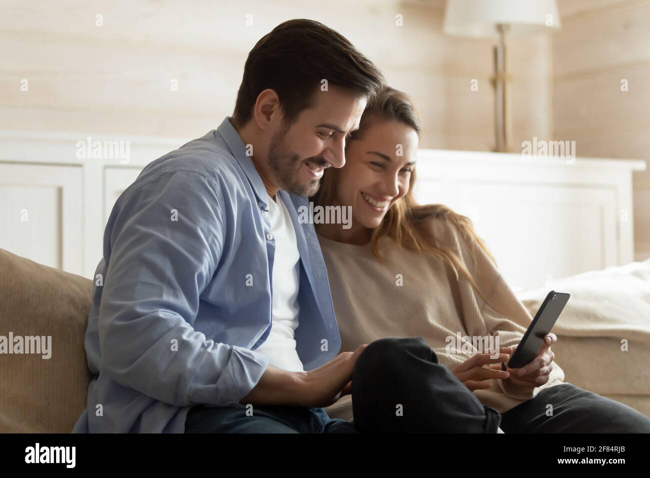 Smiling couple use cellphone talk on video call Stock Photo - Alamy