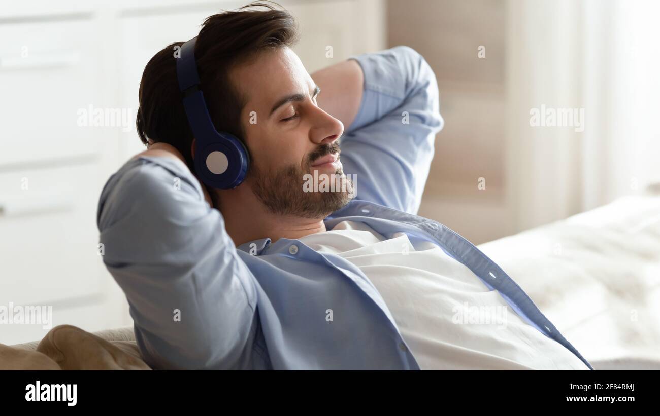 Happy man in headphones relax on couch at home Stock Photo - Alamy