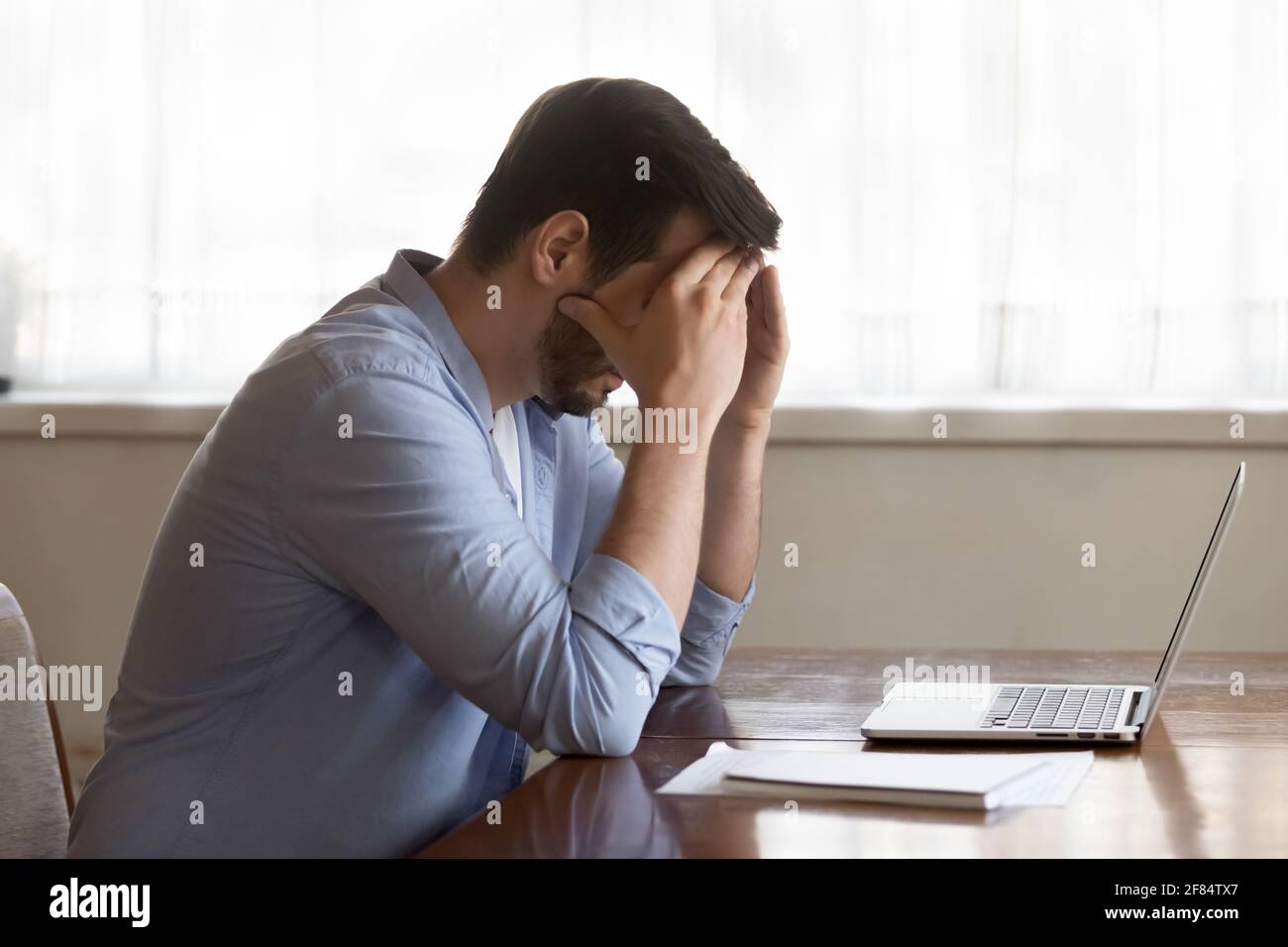 Unhappy man feel distressed working on computer Stock Photo - Alamy
