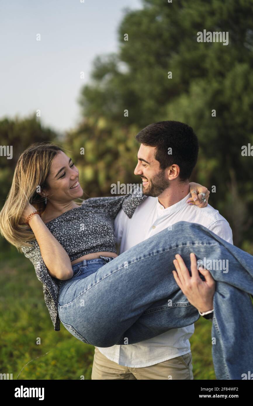 A vertical shot of a Spanish Caucasian couple in the park, him princess ...