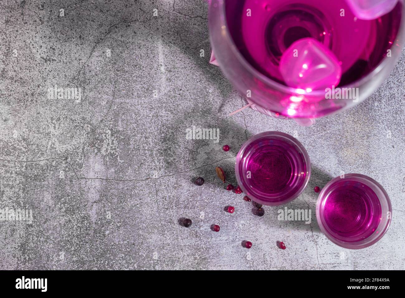 pink alcoholic drink top view with glass goblet and two shot glasses ...