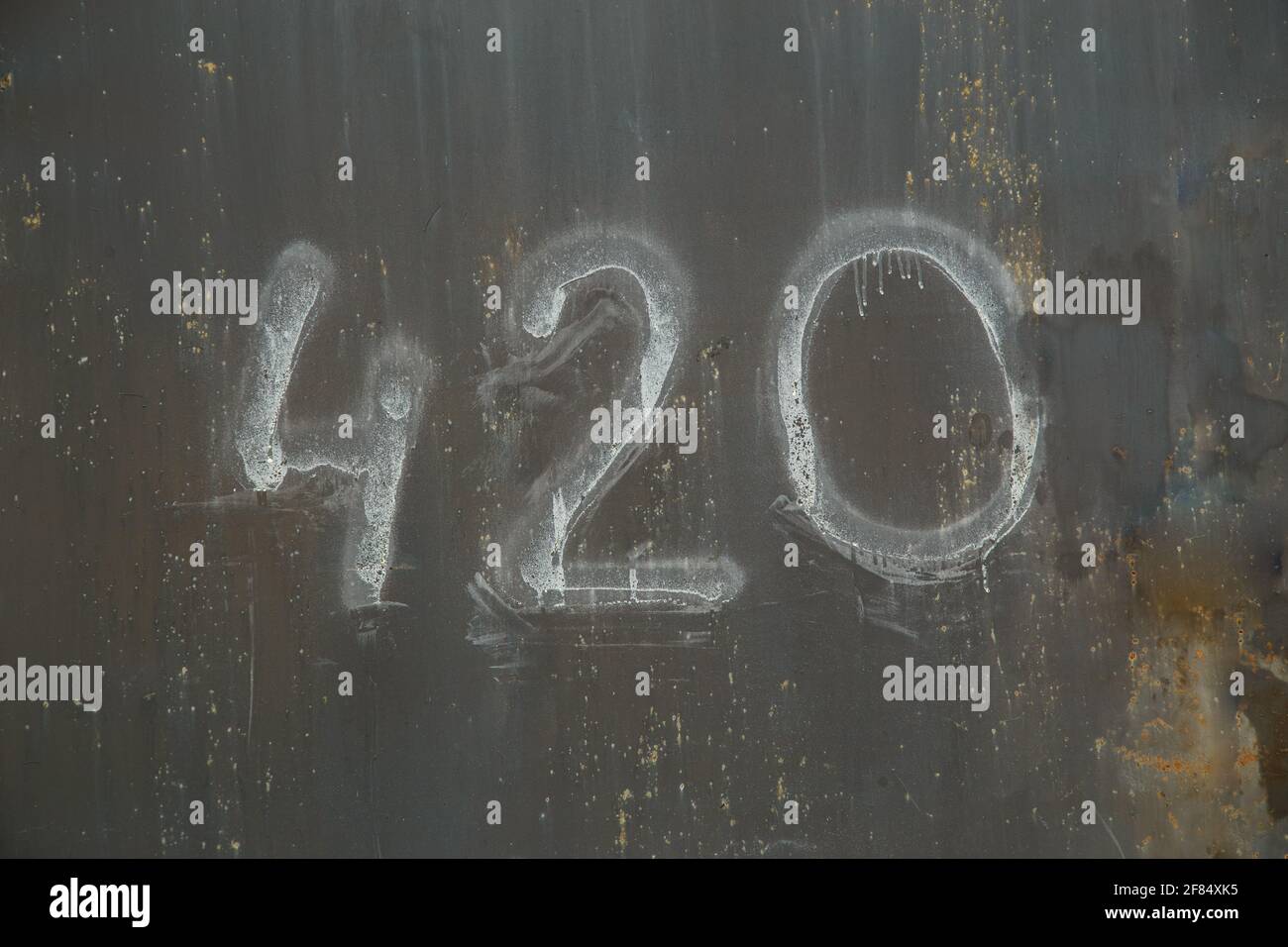 number 420 handwritten on shabby dark gray painted slat sheet steel ...