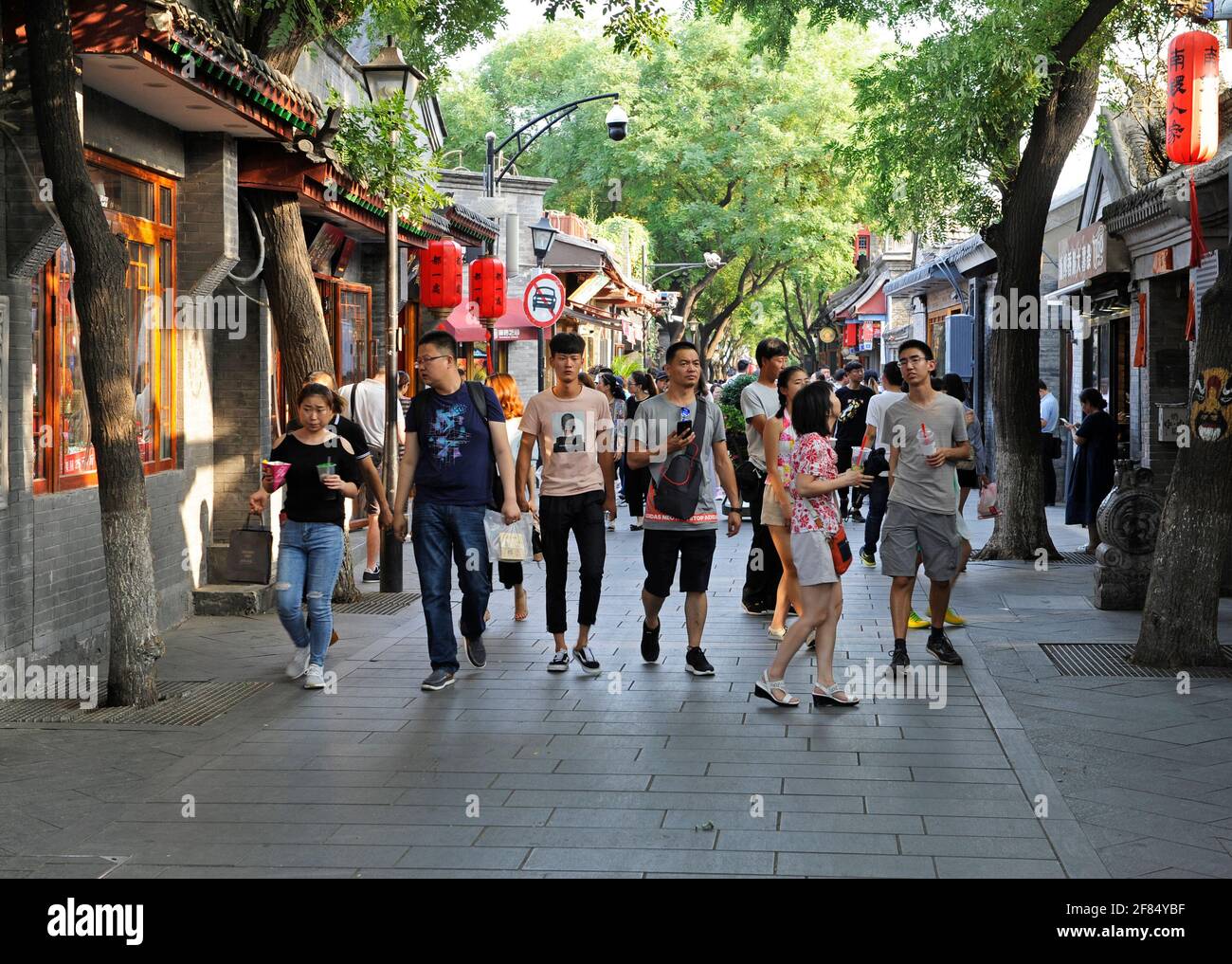 Young people walk down a pedestrianised Hutong street in the touristy ...