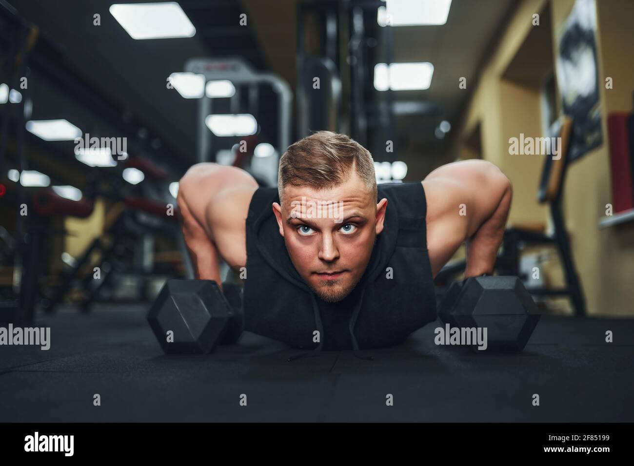 Young athletic man doing push-ups in gym. Muscular and strong guy ...