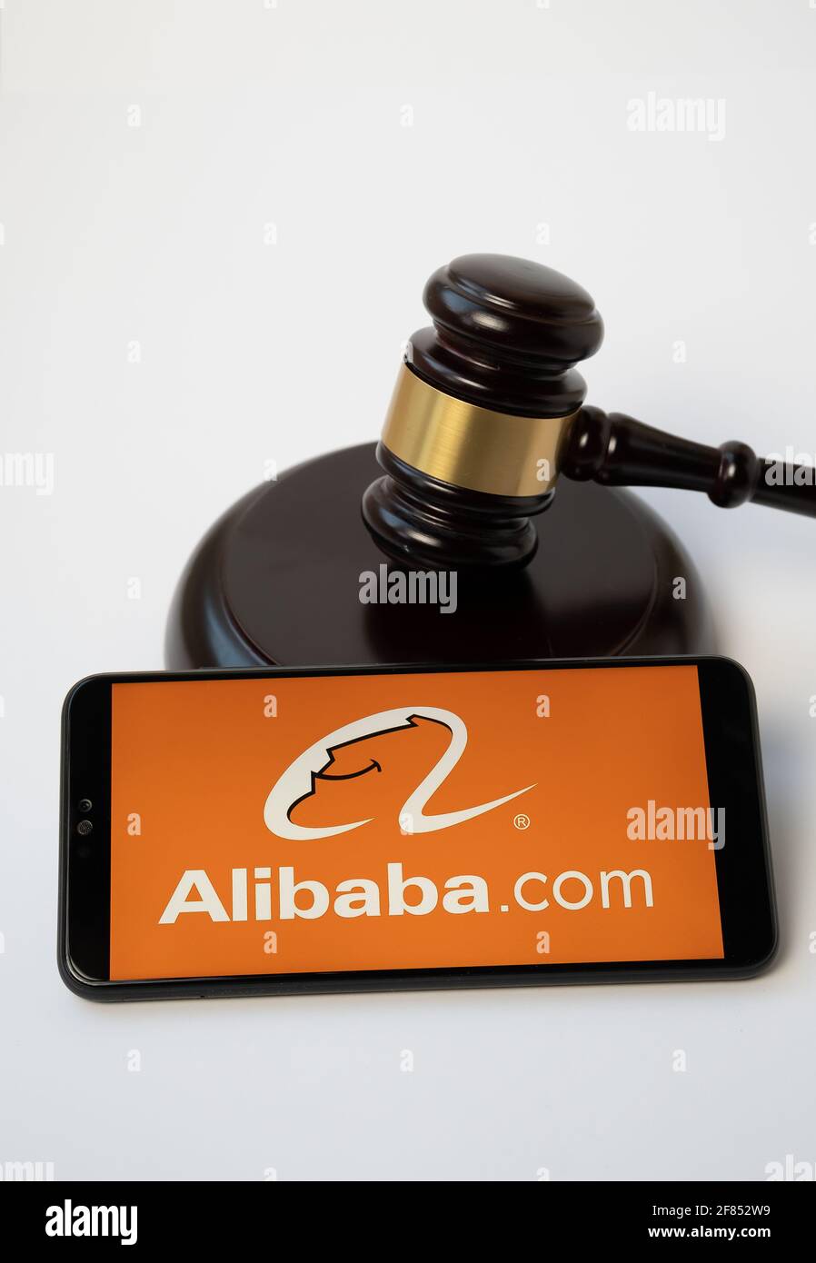Alibaba company logo seen on the smartphone and judge gavel on the ...
