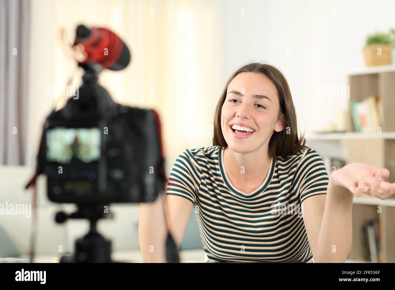 Happy influencer recording video with a dslr camera talking at camera ...