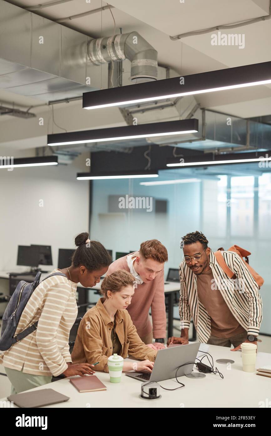 Vertical wide angle shot of diverse group of young students using ...
