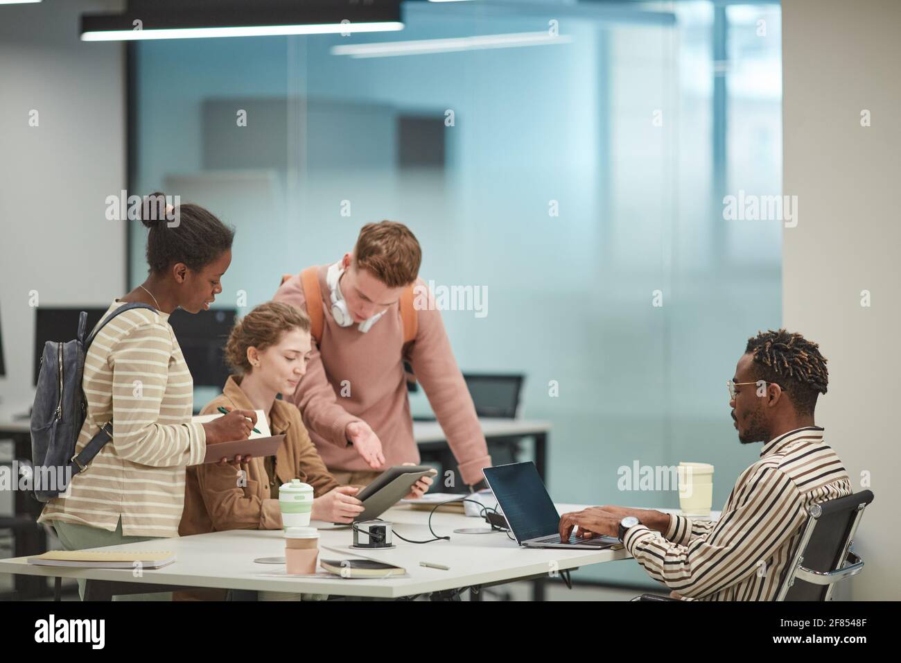 Side view at diverse group of students working together in modern ...