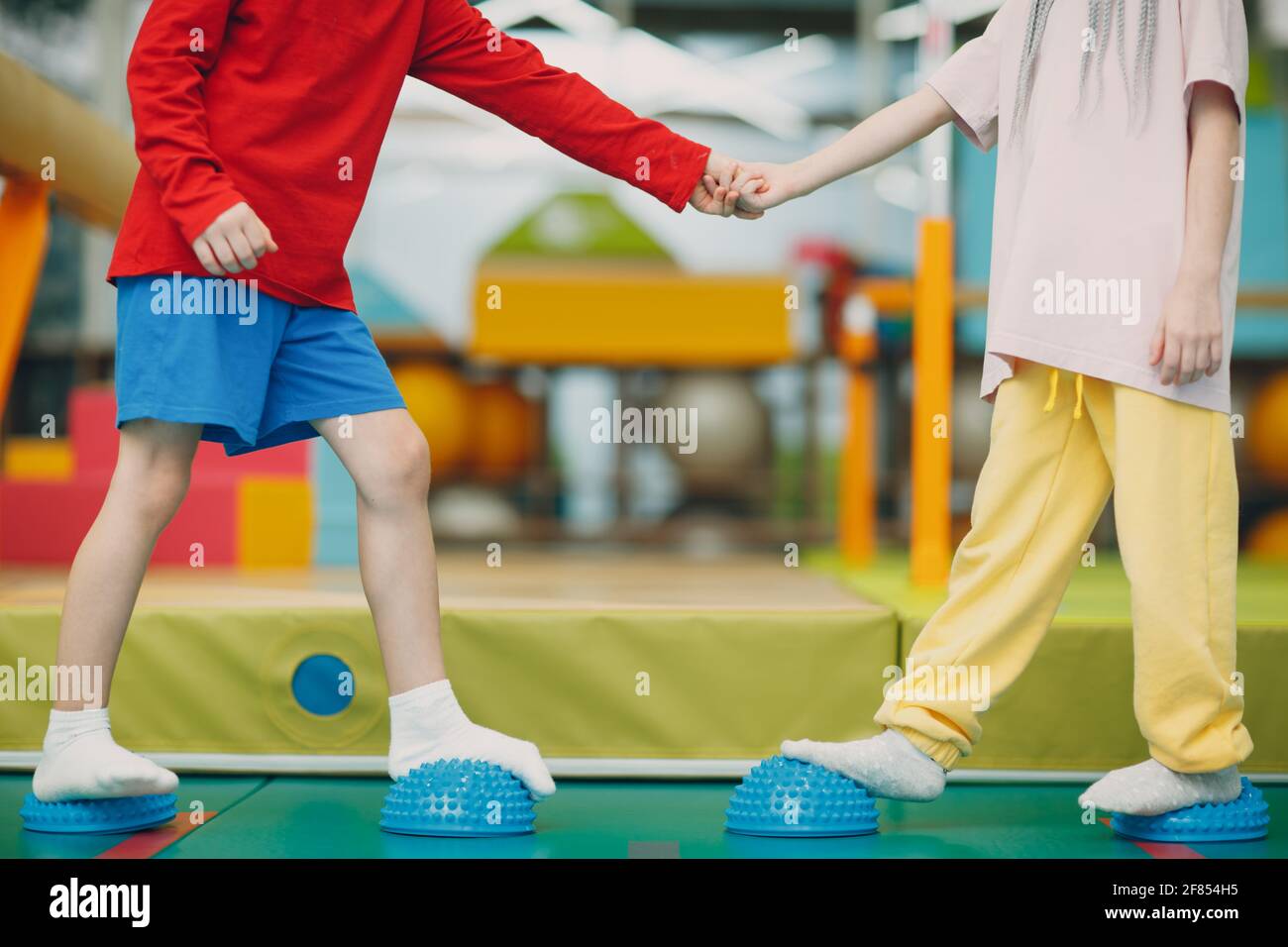 Kids doing massage hedgehog for foot legs exercises in gym at ...