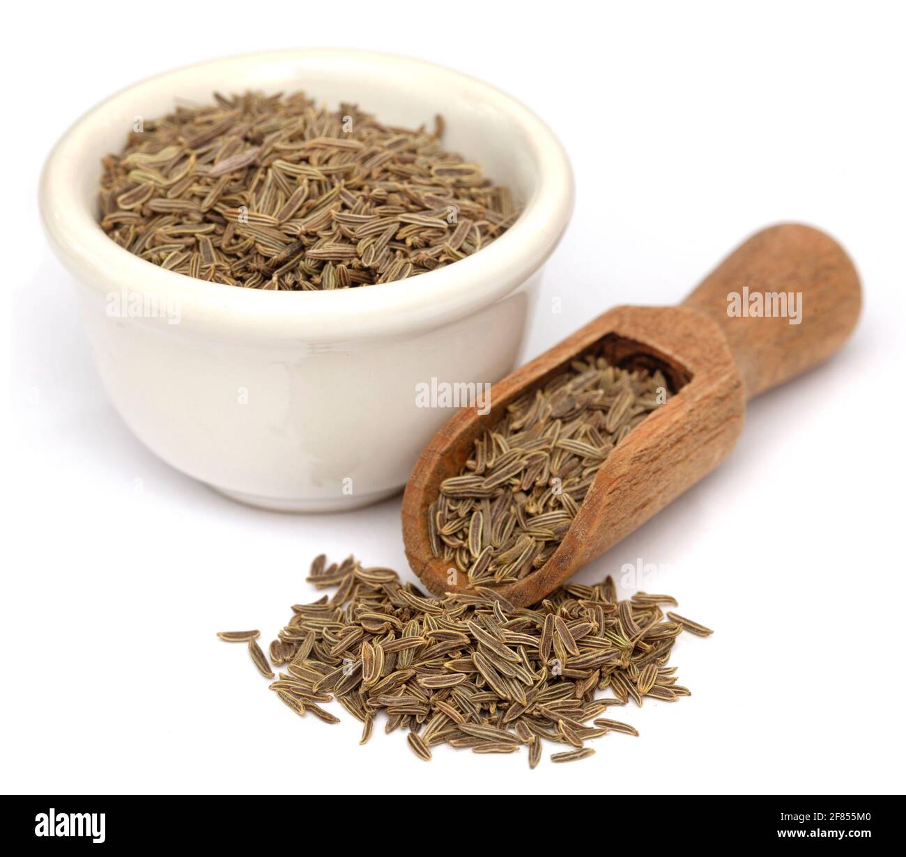 Cumin seeds whole in a bowl and scoop over white Stock Photo - Alamy