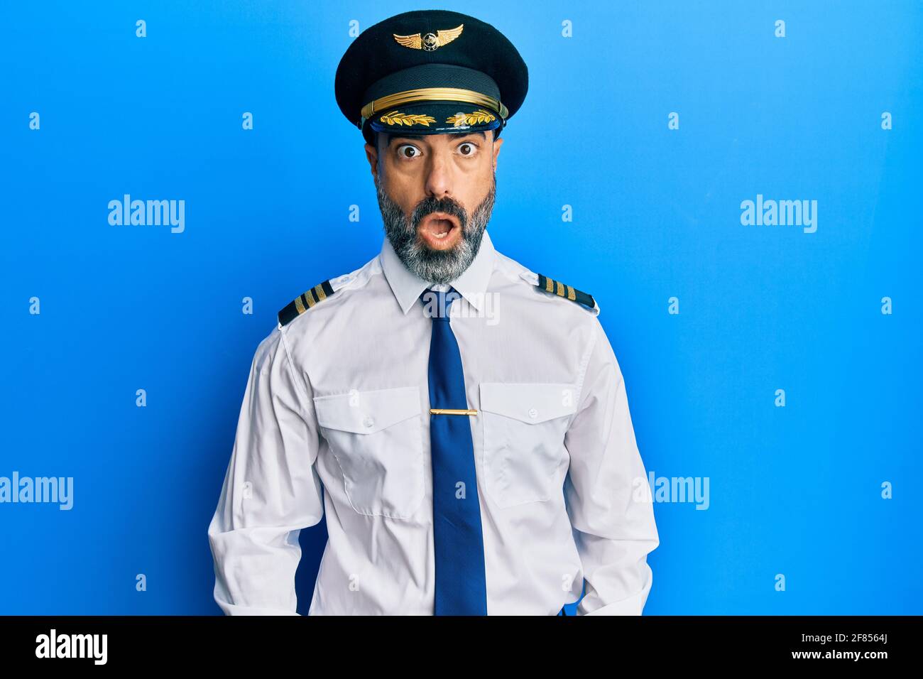Middle age man with beard and grey hair wearing airplane pilot uniform ...