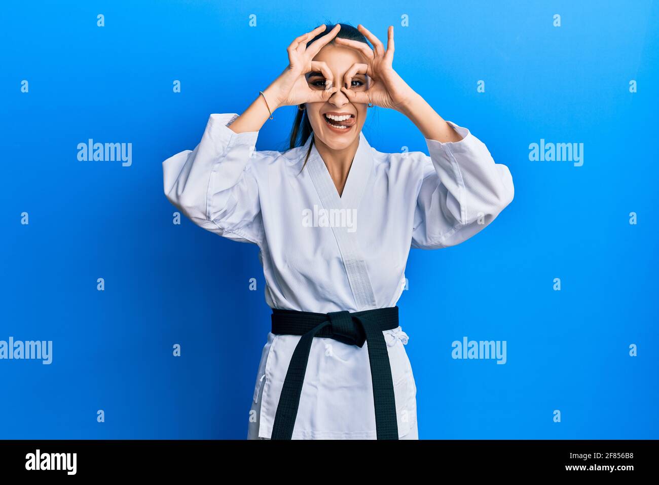 Beautiful brunette young woman wearing karate fighter uniform with ...