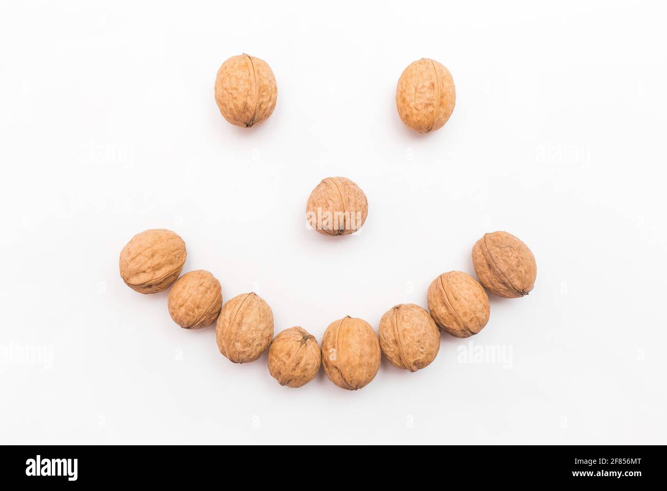 Smiling emoticon with whole walnut eyes and nose on white background ...