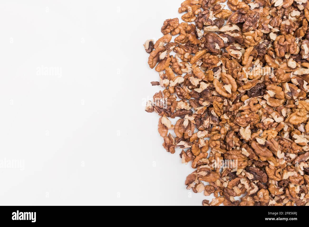 Peeled halves of walnuts in a heap isolated on white background, copy ...