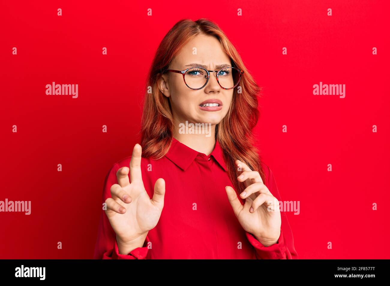 Young beautiful redhead woman wearing casual clothes and glasses over ...