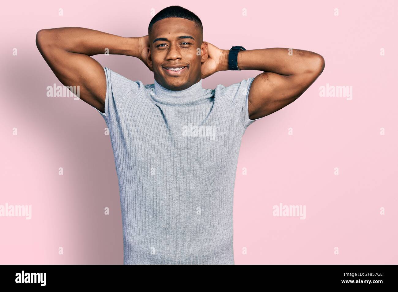 Young black man wearing casual t shirt relaxing and stretching, arms ...