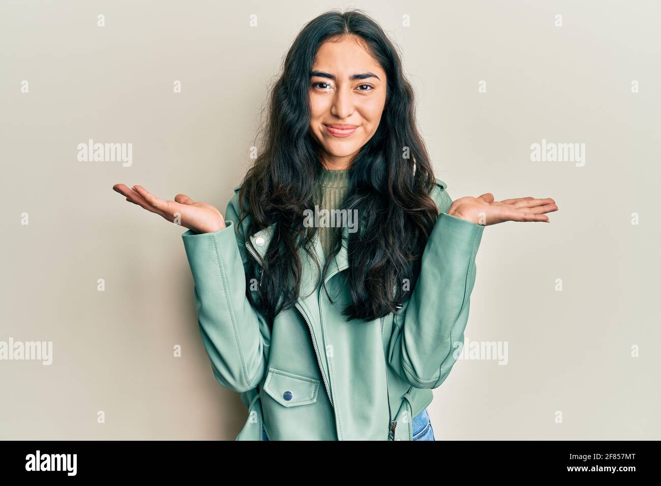 Hispanic teenager girl with dental braces wearing green leather jacket ...