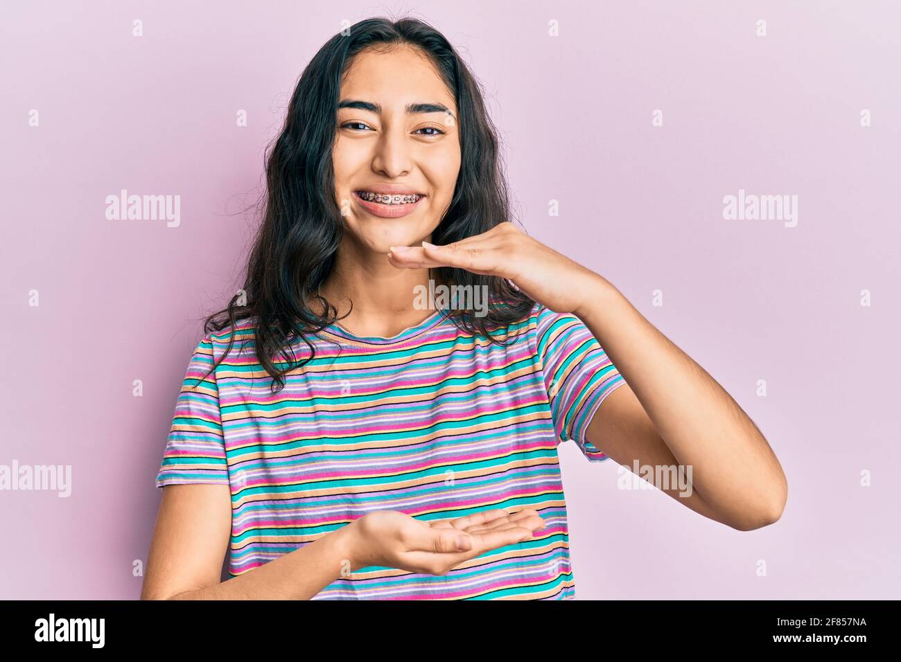 Hispanic teenager girl with dental braces wearing casual clothes ...