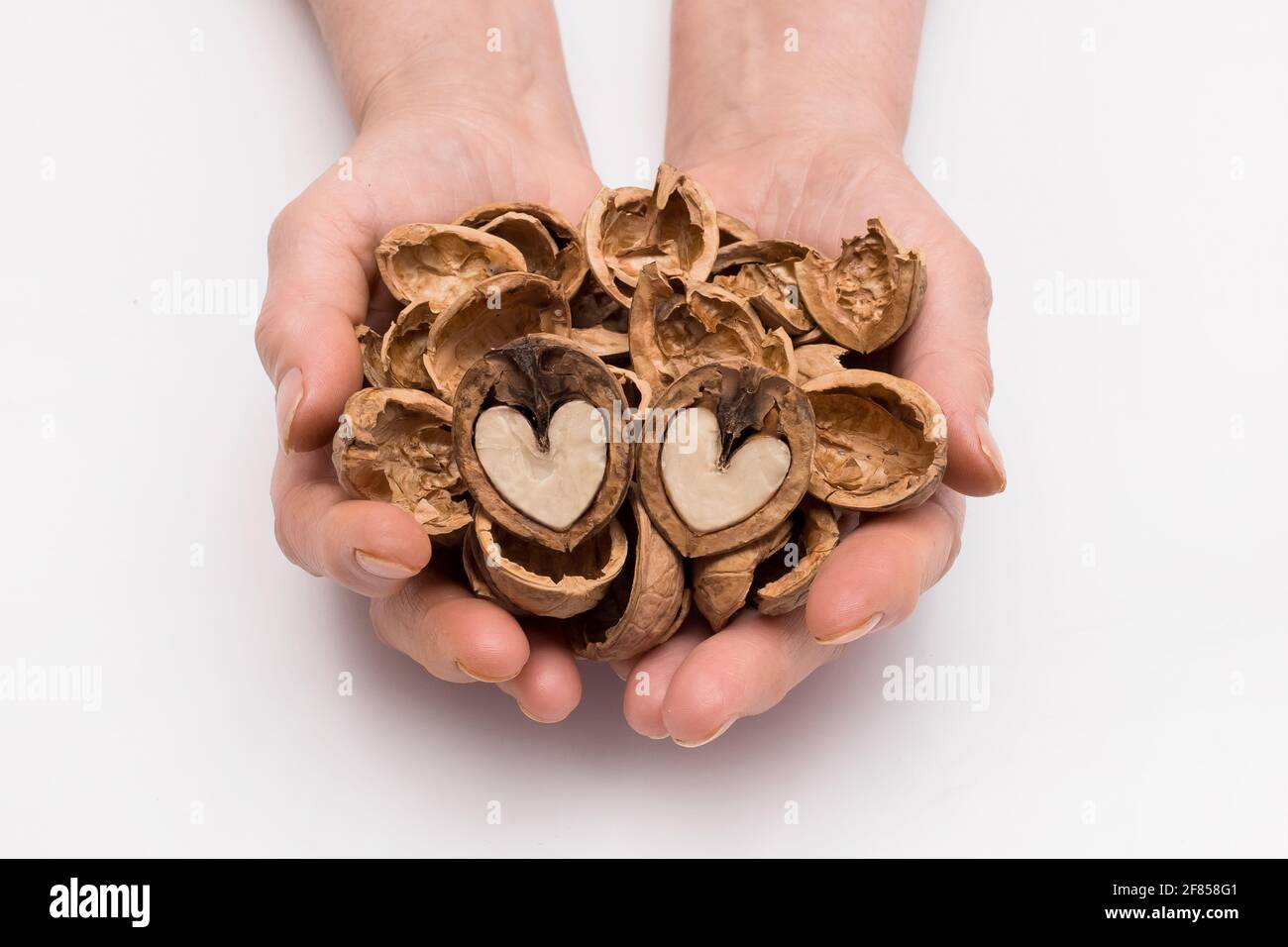Woman holds out her hands with a bunch of peeled shell and two halves ...