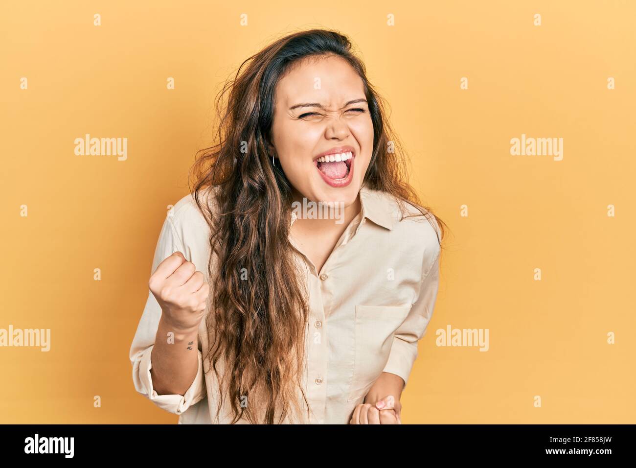 Young hispanic girl wearing casual clothes celebrating surprised and ...