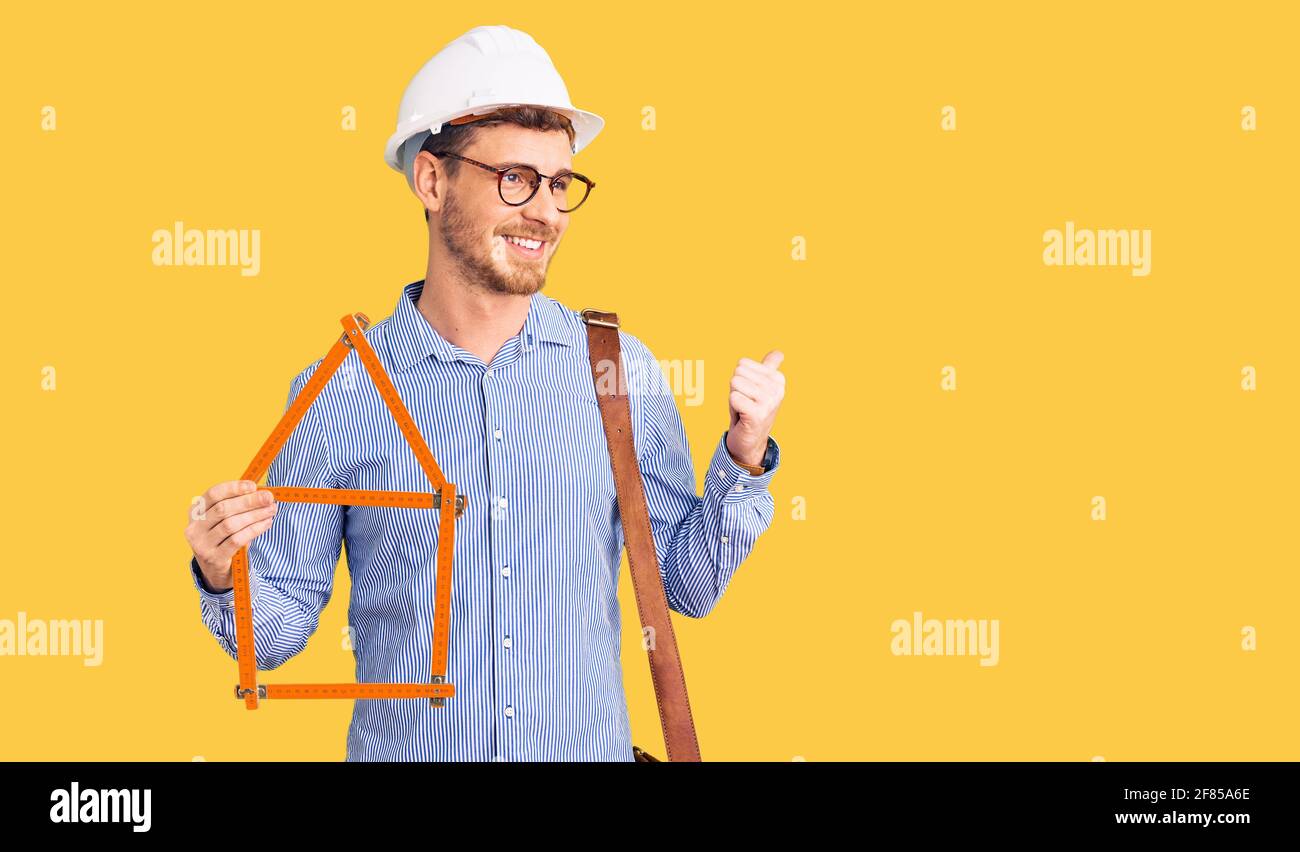 Handsome young man with bear wearing architect hardhat holding build ...