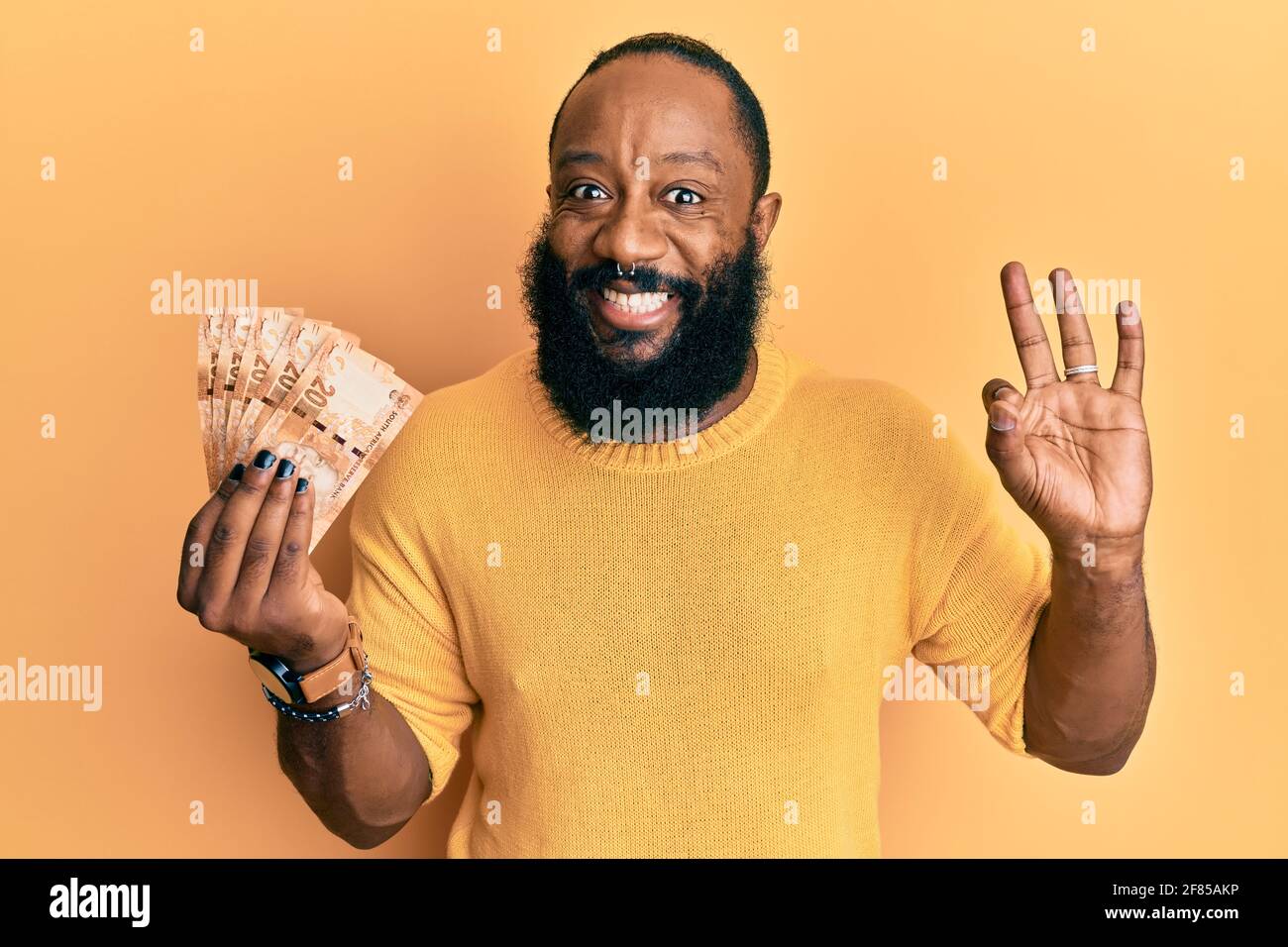 Young african american man holding south african 20 rand banknotes ...