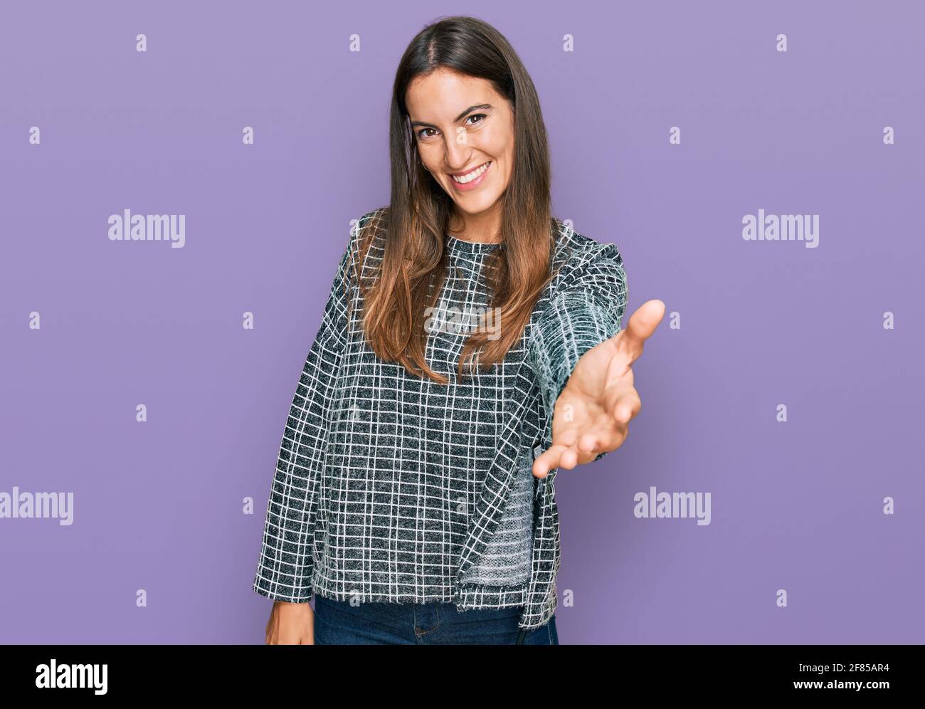 Young beautiful woman wearing casual clothes smiling friendly offering ...