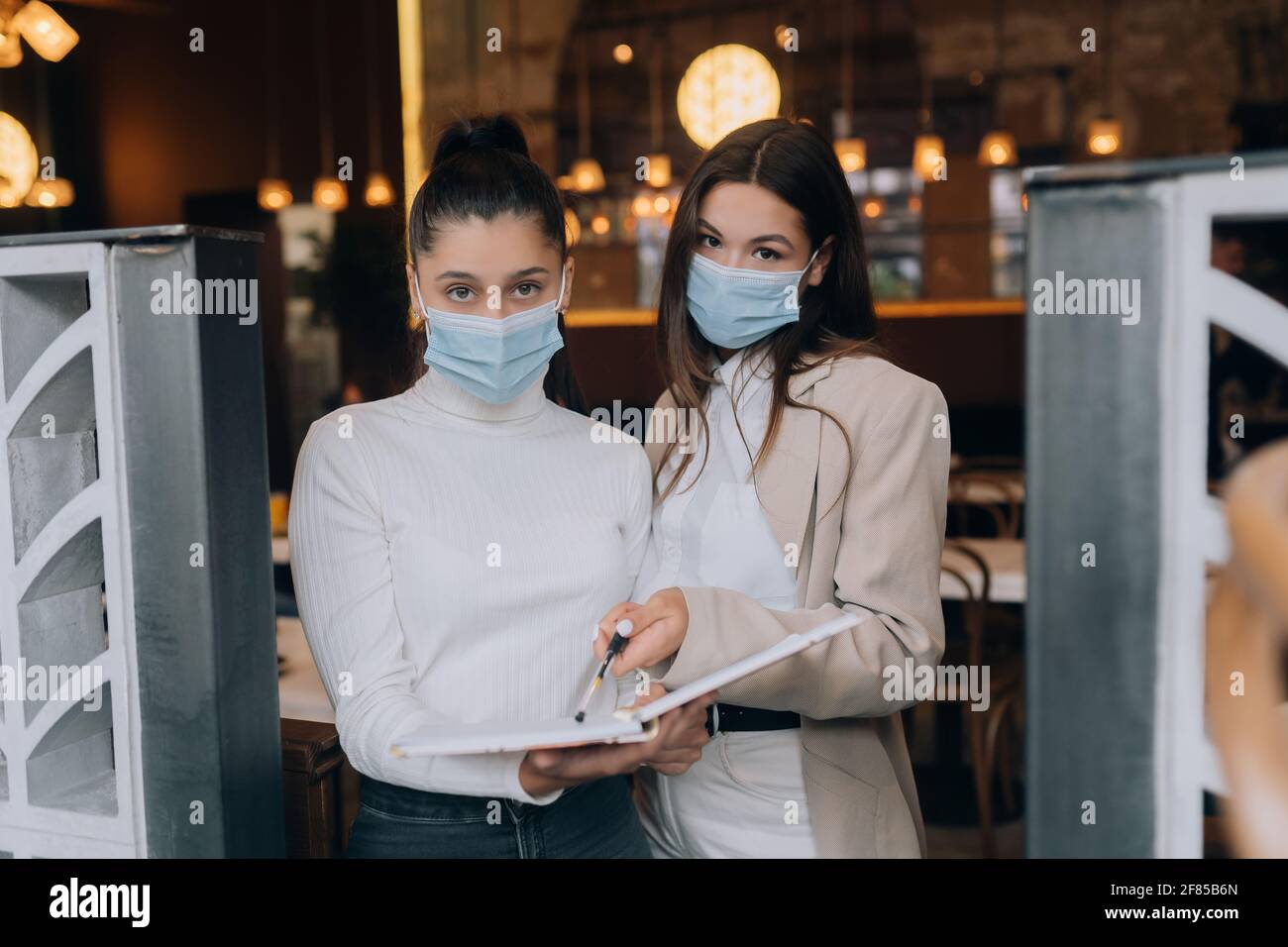 Two girls at the entrance to the building are checking people Stock ...