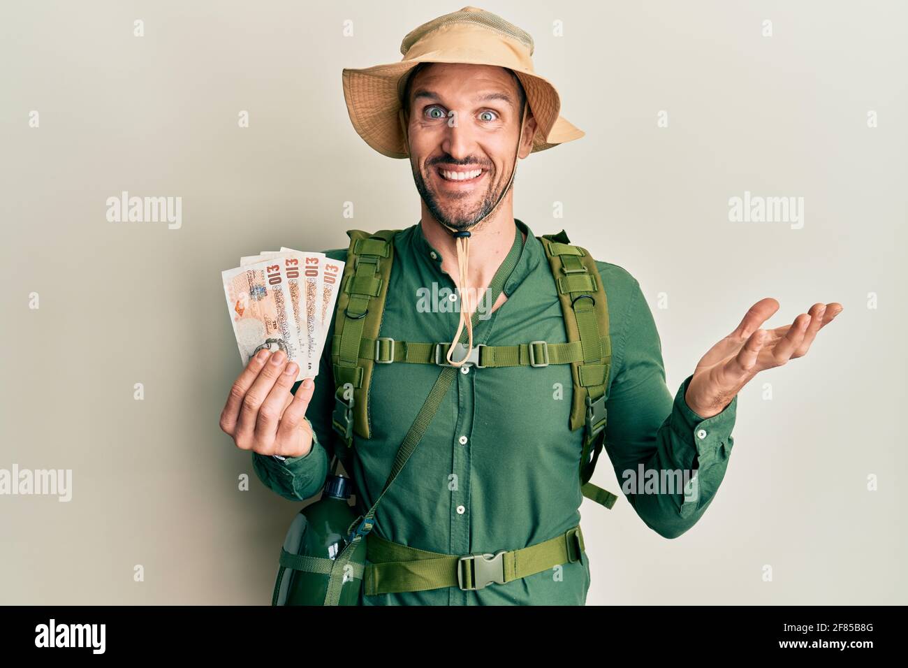 Handsome man with beard wearing explorer hat holding 10 pounds ...